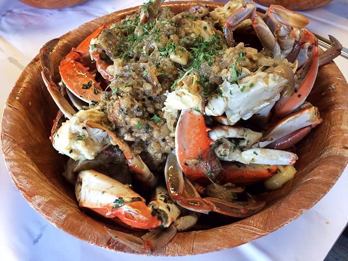 Behold the star attraction: garlic crabs piled high in a wooden bowl, glistening with buttery, garlicky goodness that will haunt your dreams.