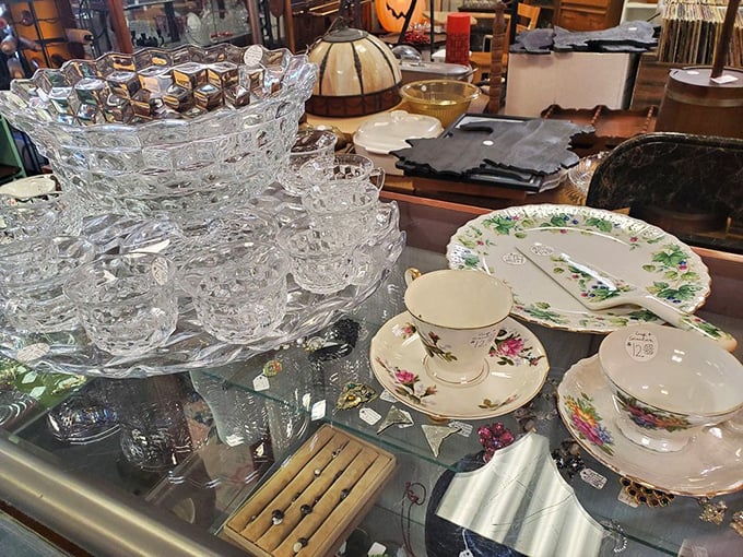 Crystal punch bowls that witnessed countless celebrations sit beside delicate teacups still whispering of afternoon gossip sessions from decades past.