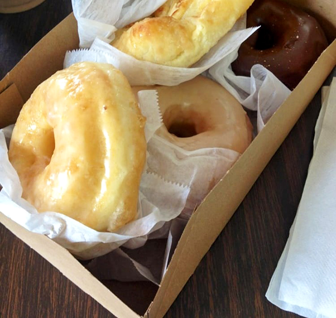 Behold the holy grail of glazed perfection&mdash;each one glistening like edible sunshine in a brown paper treasure chest.