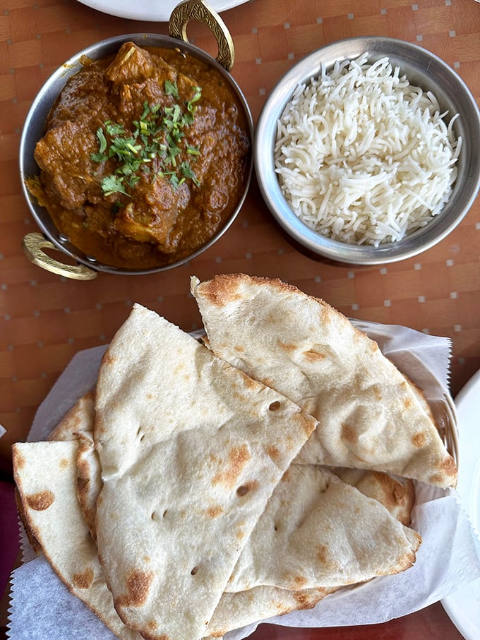 The legendary goat curry arrives in all its glory &ndash; tender meat swimming in a complex sauce that's been simmered to perfection, alongside fluffy basmati rice and fresh naan.