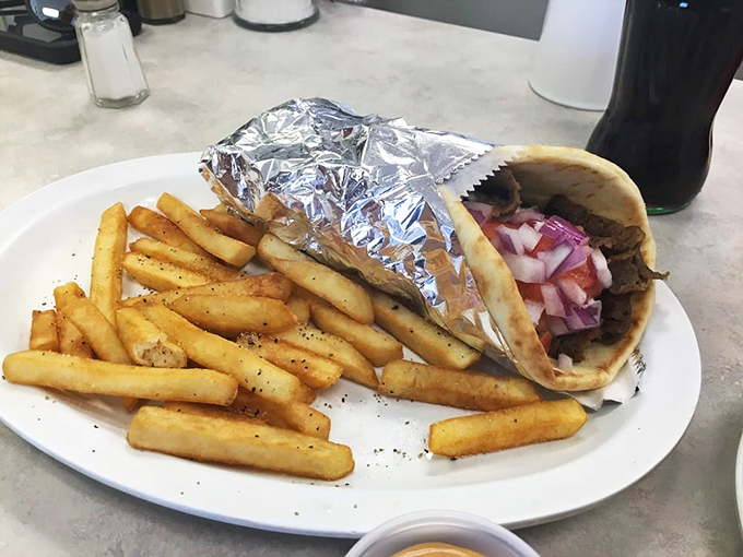 Behold the star of the show! This gyro with perfectly seasoned meat and a mountain of crispy fries would make Zeus himself descend from Olympus.