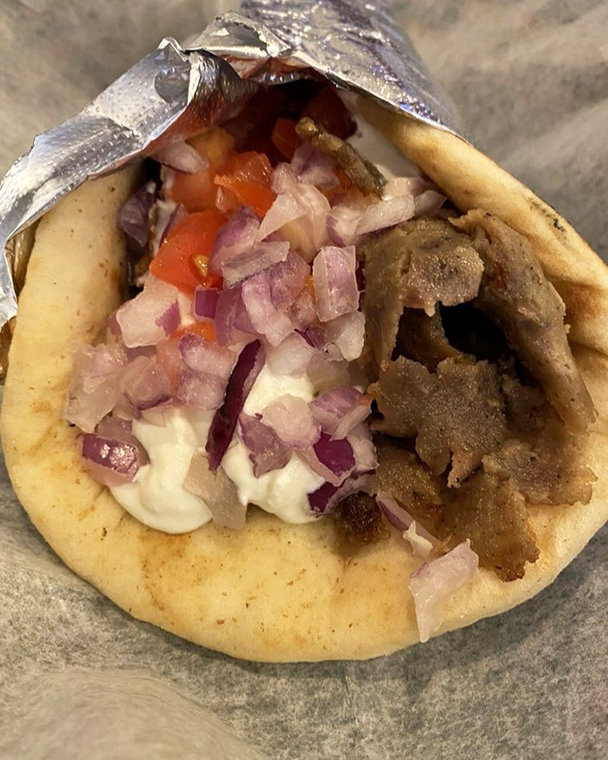 The star of the show: a perfect gyro with tender meat, creamy tzatziki, and fresh vegetables cradled in a warm pita. This is happiness wrapped in foil.