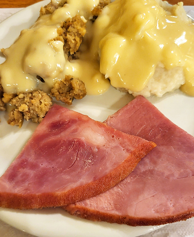 Ham loaf that makes other pork products jealous, served with stuffing and mashed potatoes swimming in gravy that deserves its own area code.