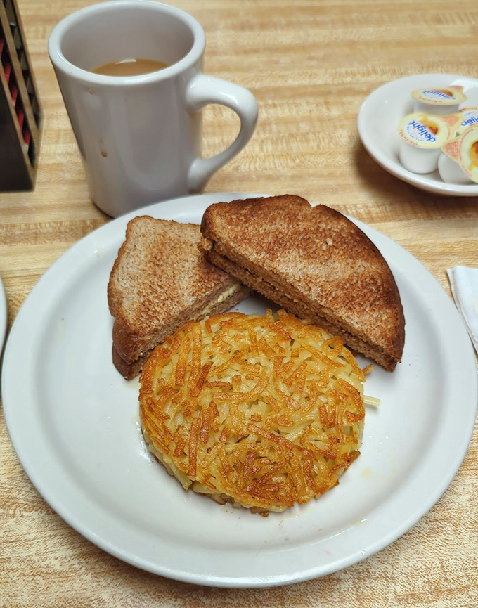 The star of the show: perfectly crispy hash browns alongside a sandwich. This golden-brown potato disc isn't just a side&mdash;it's the main event that justifies the journey.