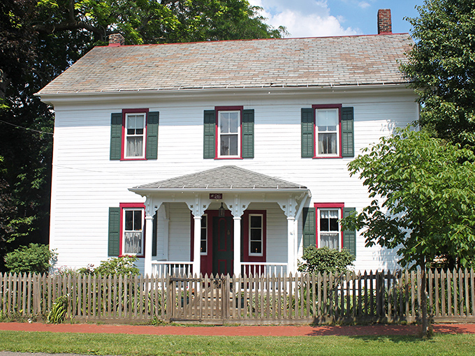 White clapboard, green shutters, and a picket fence—this home isn't playing at being historic, it's the real deal, like finding an original Beatles album in your grandparents' attic.