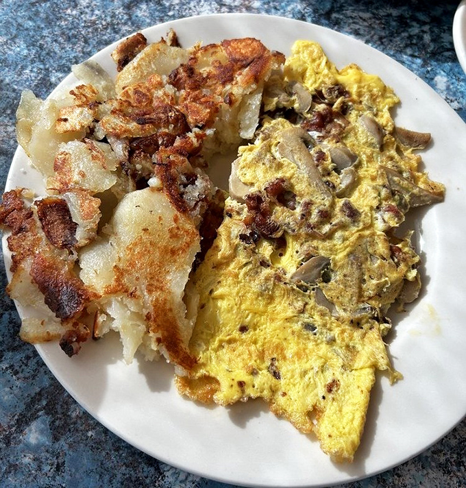 Home fries with that perfect crisp-tender balance alongside a mushroom omelet that whispers, "Yes, this is why you got out of bed."