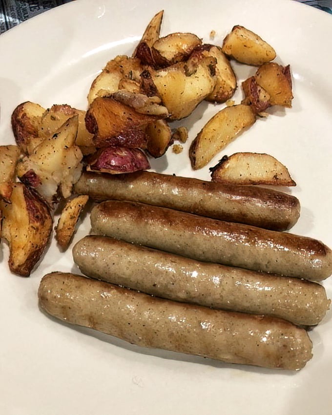Breakfast fundamentals done right: perfectly browned home fries and sausages glistening with just enough guilt to make them irresistible.