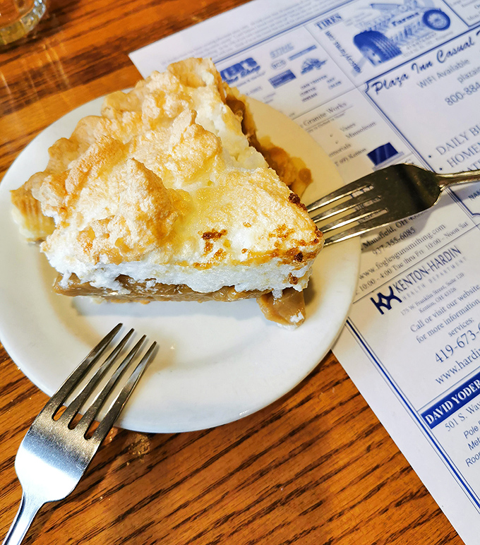 Behold the crown jewel: a slice of homemade meringue pie that stands tall enough to require FAA clearance. Worth every delicious calorie.