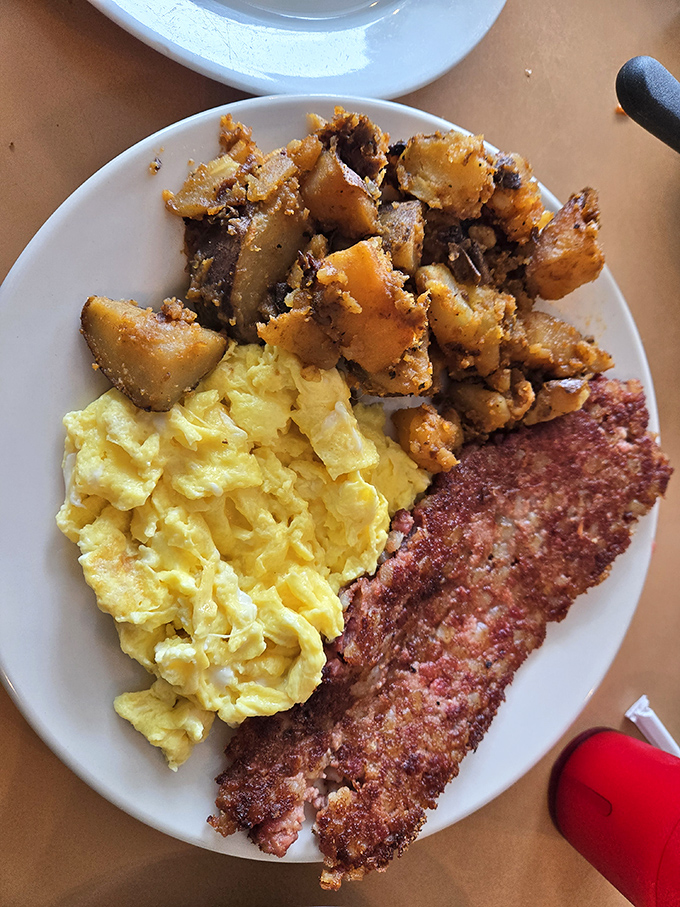 Breakfast perfection on a plate: golden home fries with that mythical crisp-tender balance, fluffy scrambled eggs, and bacon that's achieved breakfast nirvana.