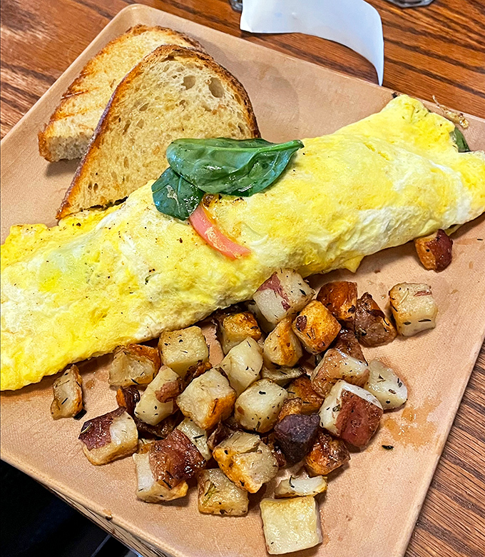 This omelet doesn't just arrive at your table&mdash;it makes an entrance, with golden perfection flanked by crispy potatoes that deserve their own fan club.