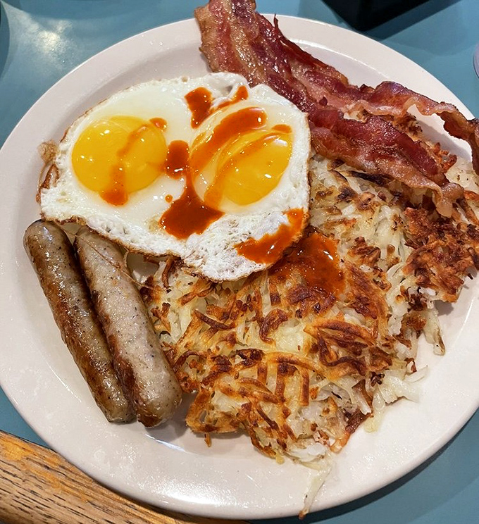 Breakfast nirvana achieved: perfectly crispy hash browns, sunny-side-up eggs with just the right jiggle, and bacon that strikes the ideal balance between chewy and crisp.