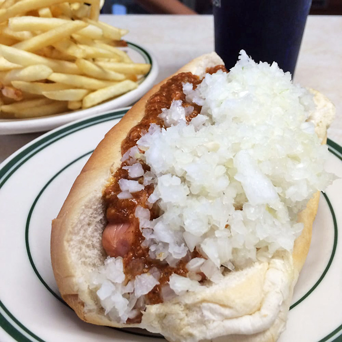 Hot dog royalty in its most authentic form&mdash;crowned with a mountain of diced onions and that legendary meat sauce that's worth every napkin.