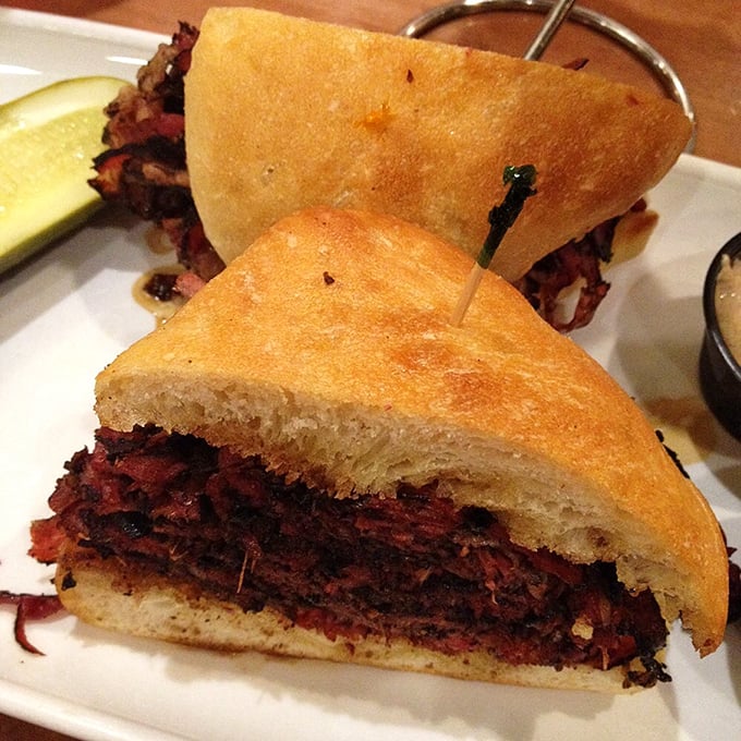 Not just a sandwich, but an architectural marvel of perfectly seasoned pastrami, stacked high enough to require a game plan before taking that first bite. 