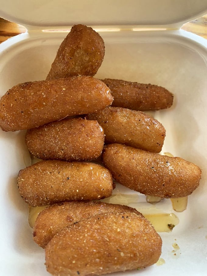 These golden-brown hush puppies aren't just side dishes; they're little cornmeal grenades of joy that might just upstage the seafood they accompany.