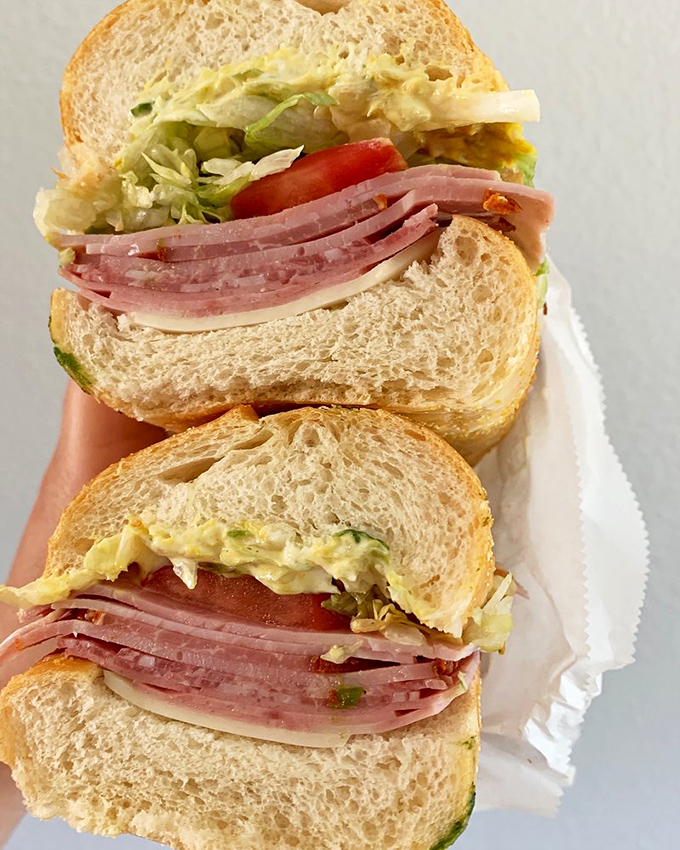 This isn't just a sandwich; it's architecture with appetite. Layers of ham, fresh veggies, and that perfect bread create edible engineering at its finest.