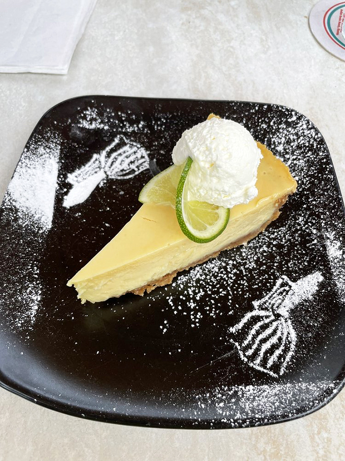 The legendary key lime pie arrives like Florida sunshine on a plate&mdash;creamy, perfectly tart filling, topped with fresh whipped cream and a lime slice garnish.