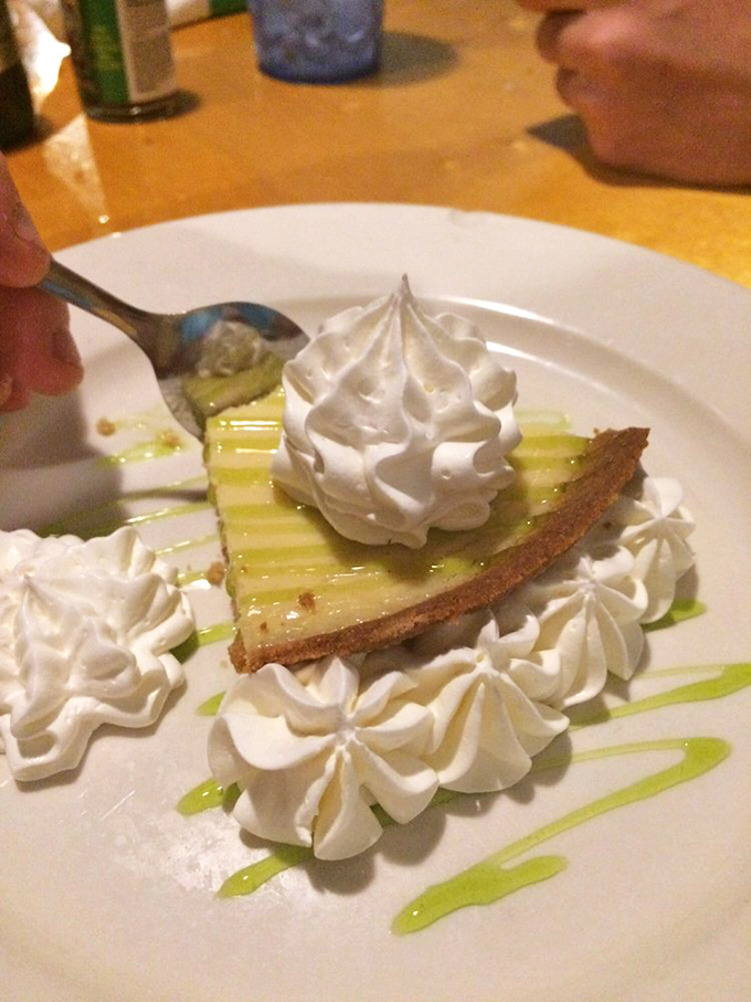 Key lime pie that strikes the perfect balance between tart and sweet, surrounded by dollops of whipped cream like little clouds of happiness.