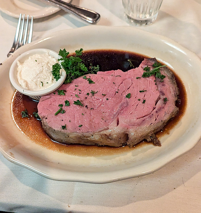 Prime rib perfection: tender, pink, and swimming in its own juices. That horseradish cream isn't just a condiment—it's a flavor revelation.
