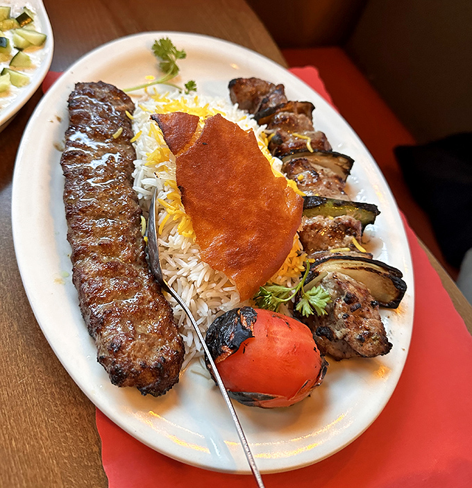This isn't just food, it's edible art. Perfectly grilled kabab resting on a bed of saffron-kissed rice, with that crispy bread crown jewel.