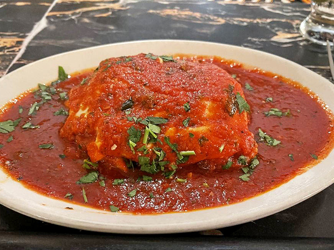 The legendary lasagna arrives like a ruby-red island in a sea of marinara &ndash; layers of pasta, cheese, and sauce that justify the cross-state pilgrimages.