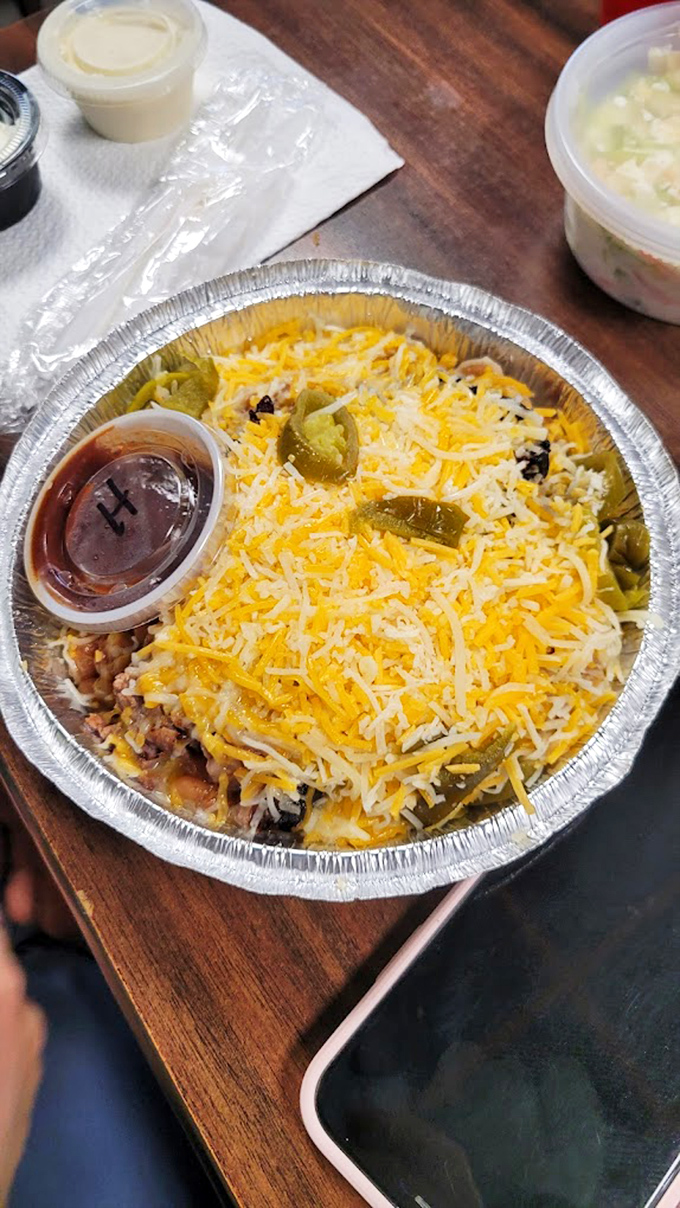 This loaded potato isn't just a side dish; it's a full-blown commitment ceremony between cheese, meat, and starch that'll have you planning your next visit before the first bite.