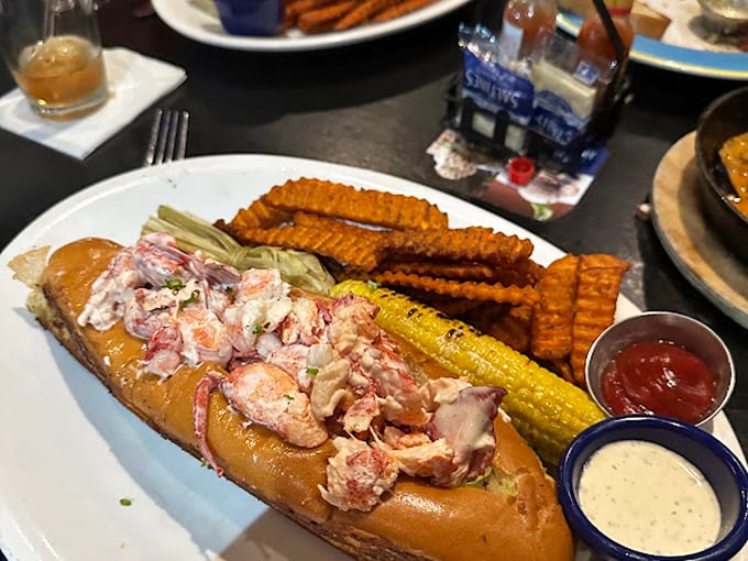 Not just a sandwich but a celebration &ndash; this lobster roll bursts with sweet meat nestled in a buttery vessel, flanked by crispy waffle fries and corn.