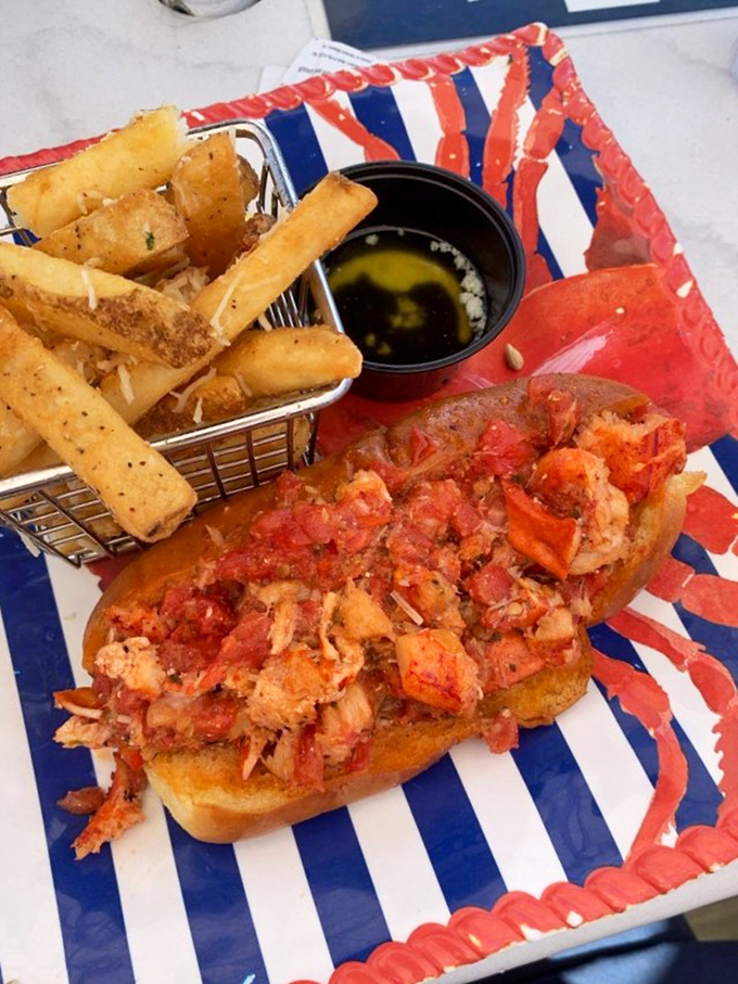 The lobster roll that launched a thousand road trips—chunky lobster meat nestled in a buttery roll with fries standing guard like delicious sentinels.