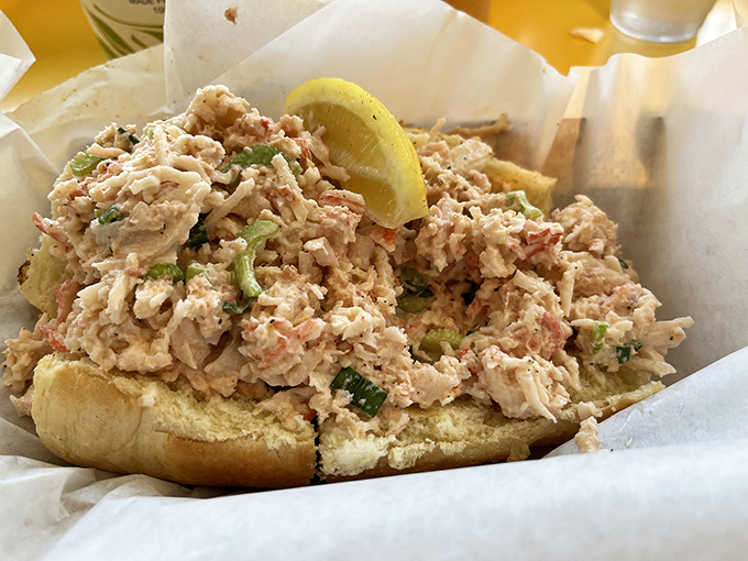 This isn't just a lobster roll; it's a seafood celebration spilling over the edges, with a lemon wedge standing by like a trusty sidekick.
