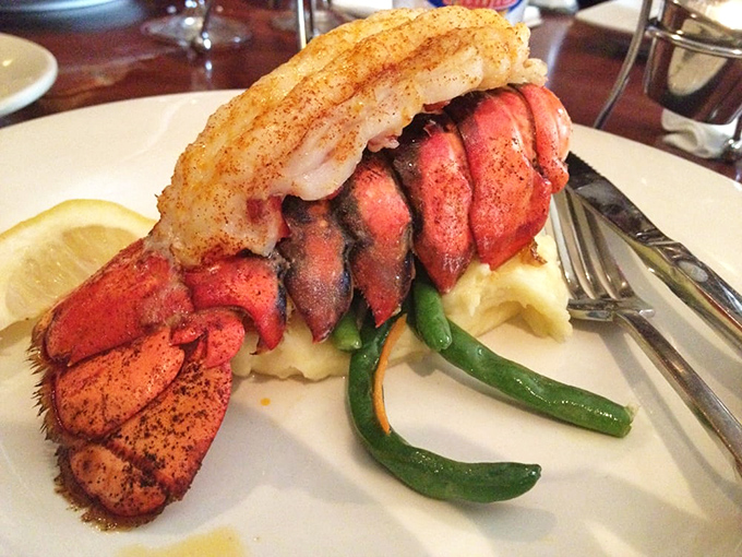 This isn't just lobster tail; it's a crustacean masterpiece perched atop whipped potatoes with green beans standing at attention, ready for their supporting role.