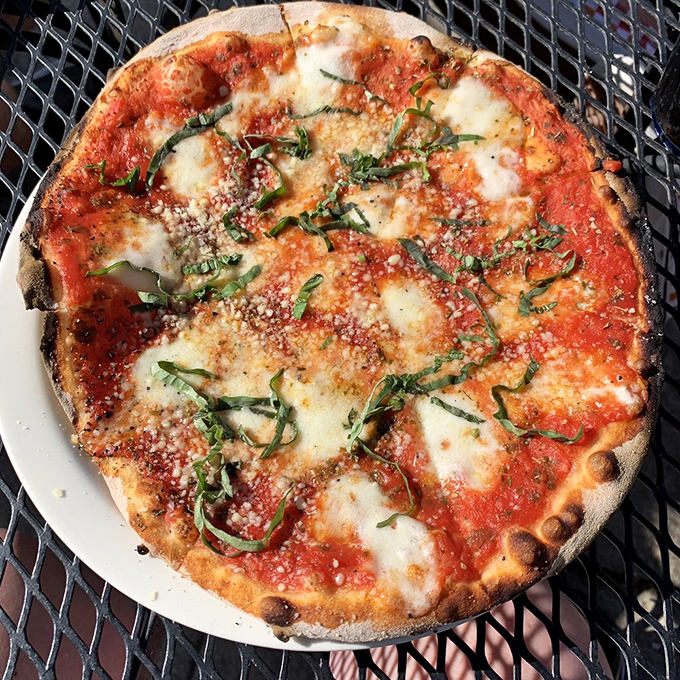 The Margherita pizza&mdash;where fresh basil dances across molten cheese and bright tomato sauce on a perfectly charred crust. Simplicity at its most sublime.
