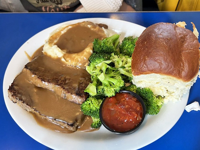 Behold the star of the show—meatloaf that doesn't just sit on the plate, it commands attention with gravy that should run for office.