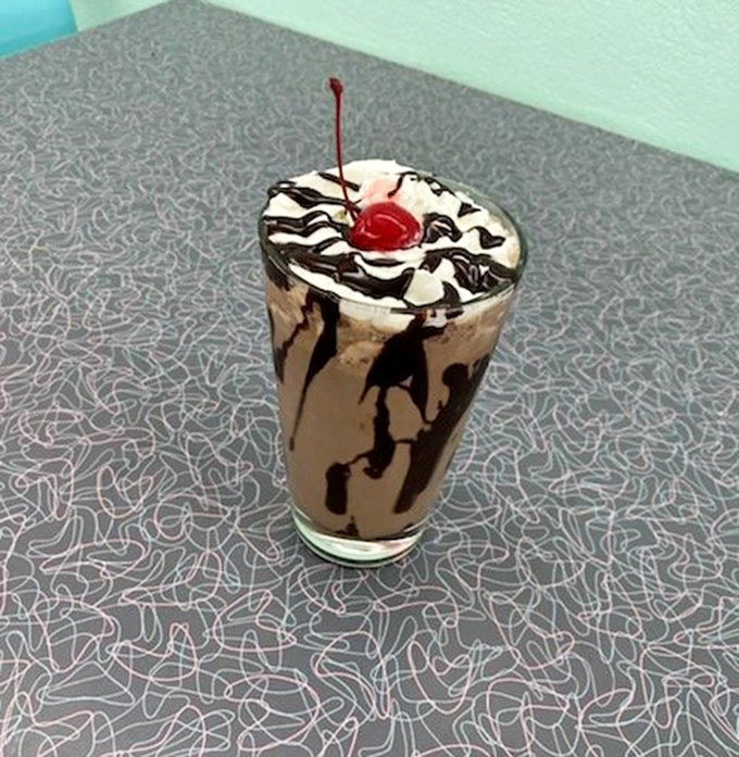 This isn't just a milkshake &ndash; it's a chocolate masterpiece topped with whipped cream, drizzled with syrup, and crowned with a cherry.