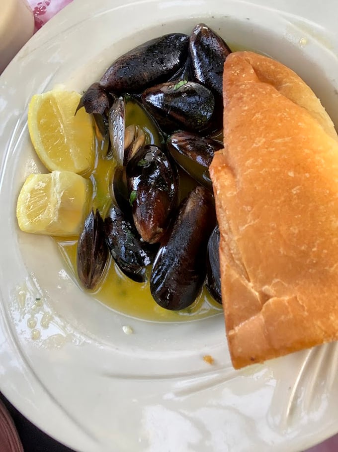 These mussels arrive like little black pearls, swimming in butter that could make a saint sin happily.