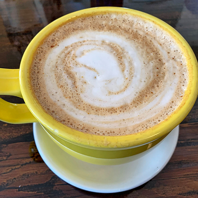 This sunshine-yellow cup cradles a perfect swirl of caffeine and comfort. The latte art is just showing off at this point.