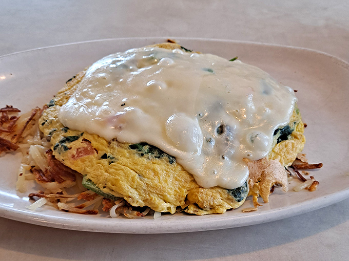 This isn't just an omelet&mdash;it's a golden pillow of egg perfection crowned with a sauce that would make French chefs nod in approval.