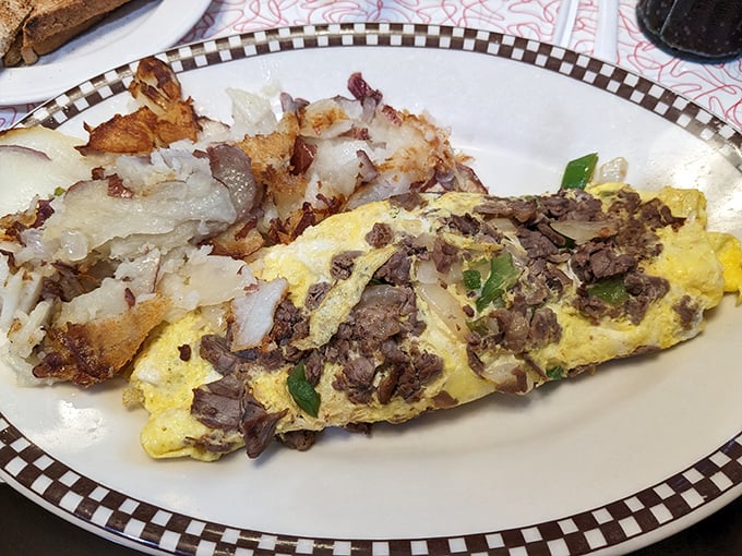 This isn't just an omelet&mdash;it's a masterpiece of morning architecture with perfectly folded eggs embracing savory steak and crispy hash browns.