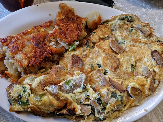 This isn't just an omelet; it's a masterclass in diner perfection. Fluffy eggs embracing savory fillings with crispy home fries standing guard.