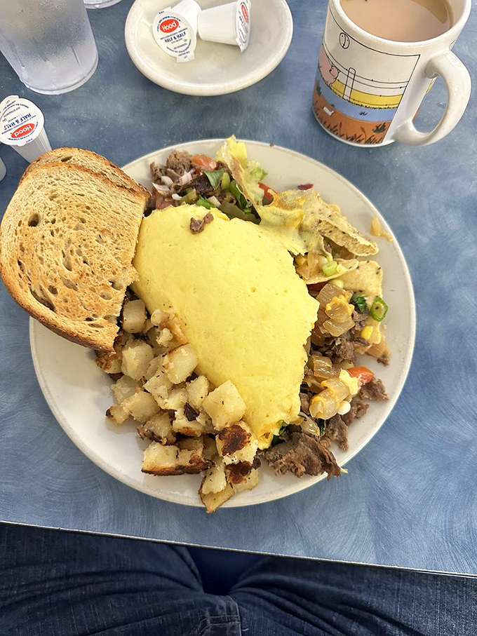 Breakfast architecture at its finest. This omelet doesn't just sit on the plate&mdash;it commands it, with home fries standing guard like delicious sentinels.