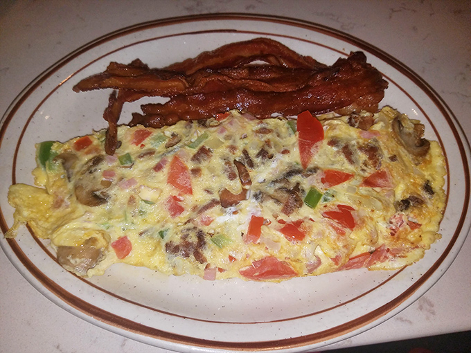 Behold the Western omelet in its natural habitat &ndash; fluffy egg exterior giving way to a treasure trove of peppers, ham, and cheese.