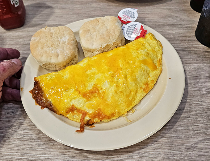 This cheese-blanketed omelet alongside fresh biscuits isn't just breakfast&mdash;it's edible therapy that makes Monday mornings bearable again.