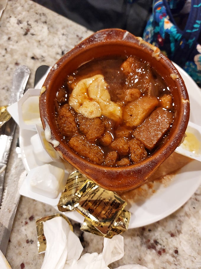 Behold the legendary French onion soup in its natural habitat&mdash;a ceramic crock filled with savory broth, tender bread, and enough melted cheese to make a cardiologist wince.