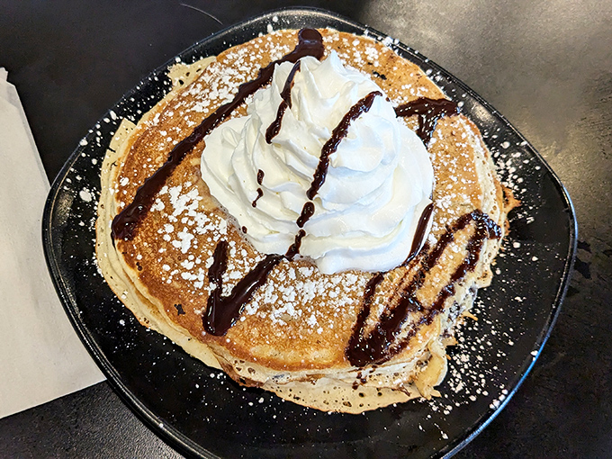 This isn't just a pancake; it's a fluffy cloud of joy topped with whipped cream and chocolate drizzle that whispers, "Diet tomorrow."