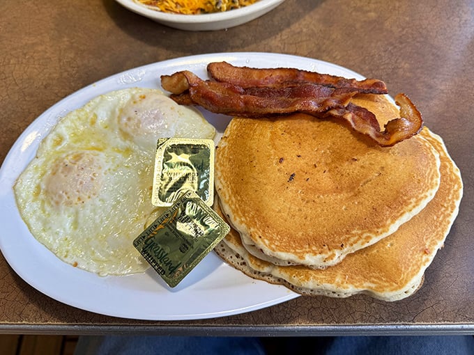 Fluffy pancakes tower beside perfect eggs - this plate could make Sunday mornings jealous everywhere.