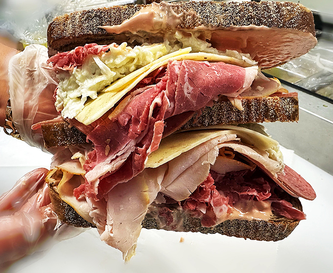 Architecture of deliciousness! This towering creation showcases the art of proper sandwich construction &ndash; meat, cheese, and slaw in perfect harmony.