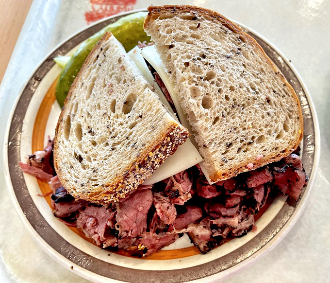 This isn't just a sandwich; it's an engineering marvel of perfectly stacked pastrami that requires both hands and complete concentration.