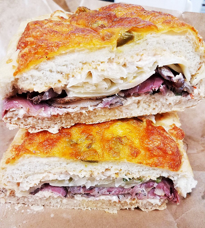 Behold: the sandwich that launched a thousand road trips. That cheese-crusted bread and perfectly layered meat is architecture you can eat.