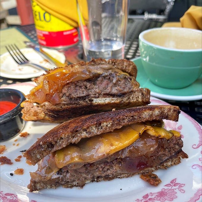 Behold the patty melt in its natural habitat—perfectly grilled bread, melty cheese, and caramelized onions creating the holy trinity of sandwich perfection.