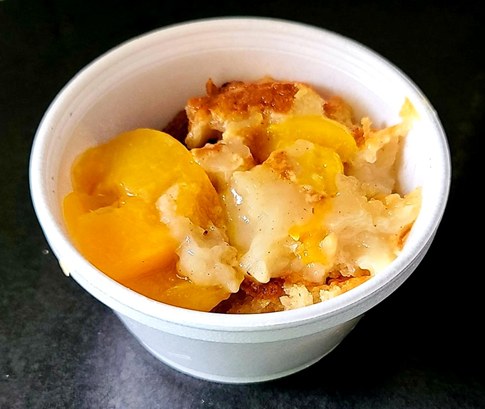 This isn't just peach cobbler; it's summer sunshine in a cup. Golden fruit nestled in buttery crumble that makes you want to hug whoever made it.