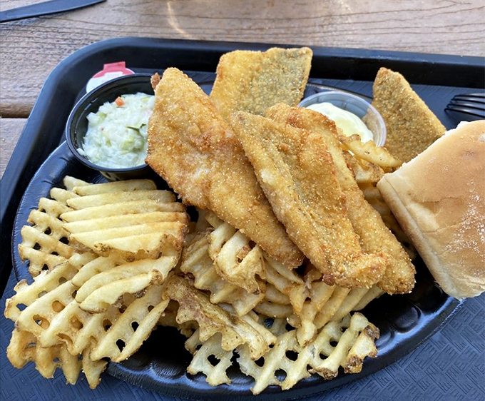 Golden-fried perch fillets nestled atop waffle fries with a side of coleslaw &ndash; a holy trinity of Great Lakes cuisine that demands reverent silence between bites.