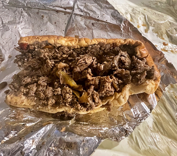 Behold the star of the show: thinly sliced ribeye piled high on that perfect Amoroso roll. No Instagram filter needed for this beauty.